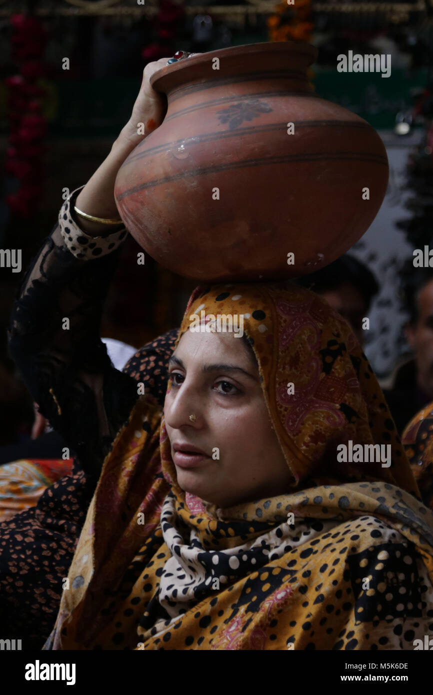 Pakistani women devotees carrying pitchers of rose water for ablution ...