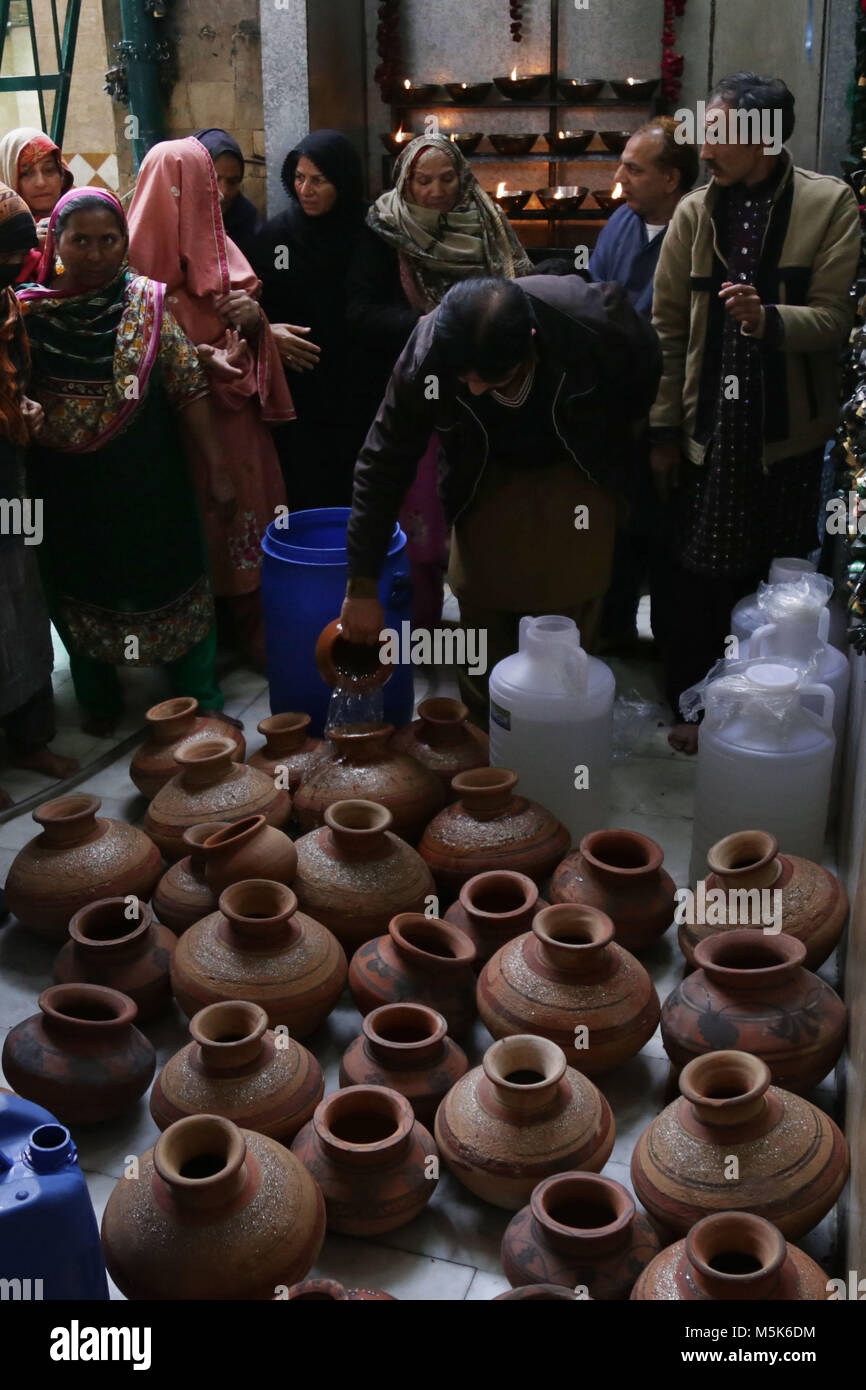 Pakistani women devotees carrying pitchers of rose water for ablution ...