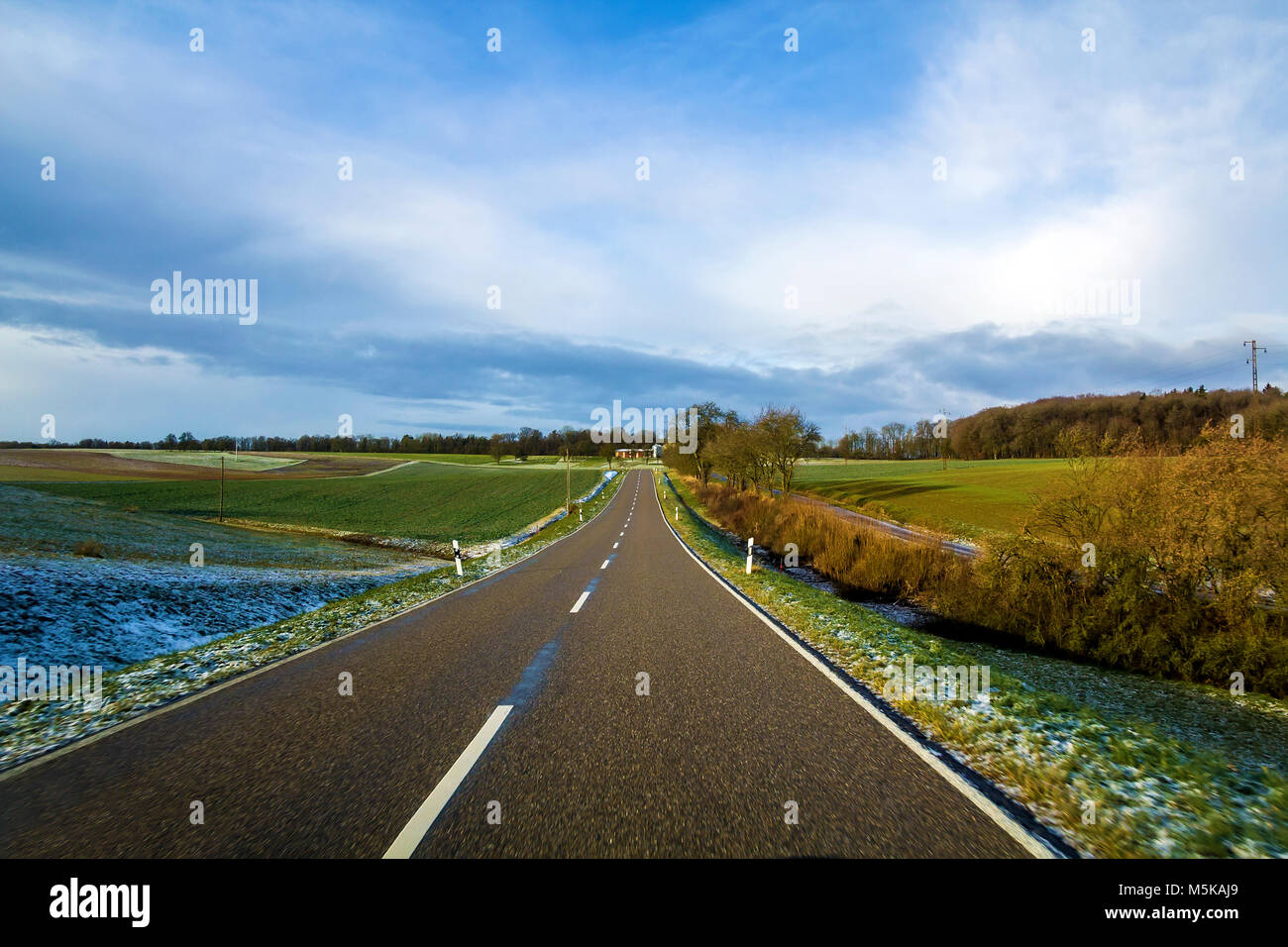 Empty black asphalt road between green fields Stock Photo - Alamy