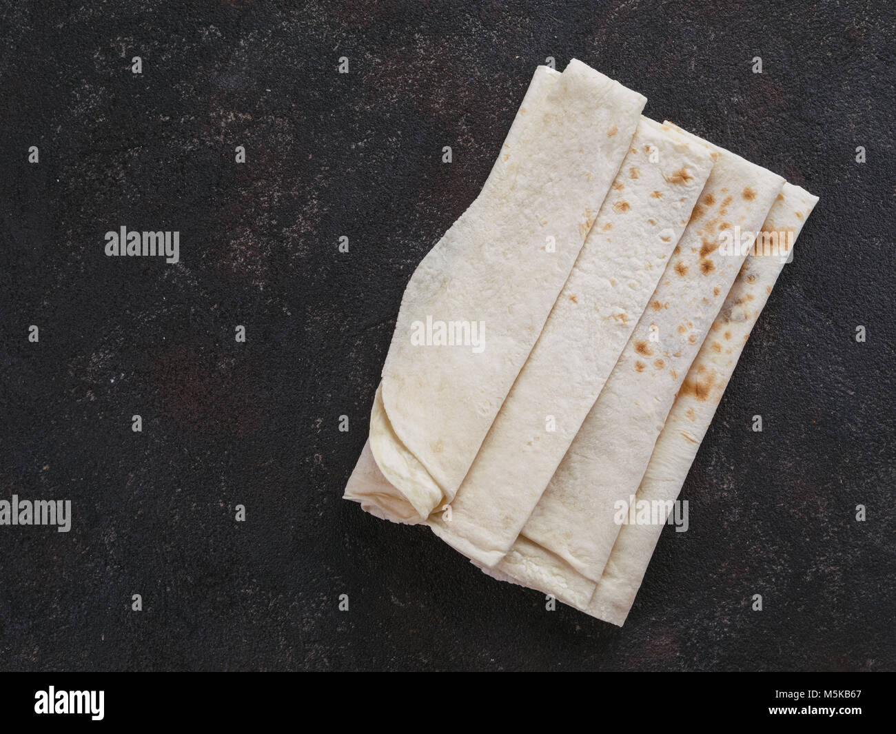 Armenian flat bread lavash. Pita bread on black cement background. Copy ...