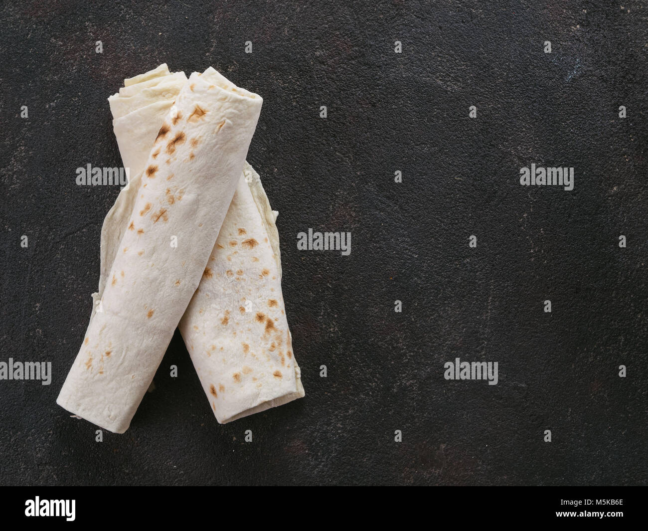 Armenian flat bread lavash. Pita bread on black cement background. Copy ...