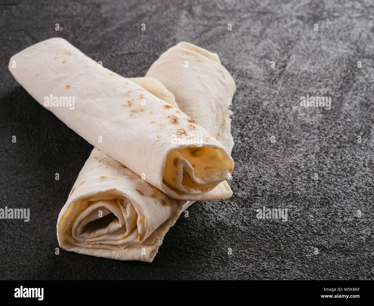 Armenian flat bread lavash. Pita bread on black cement background. Copy ...