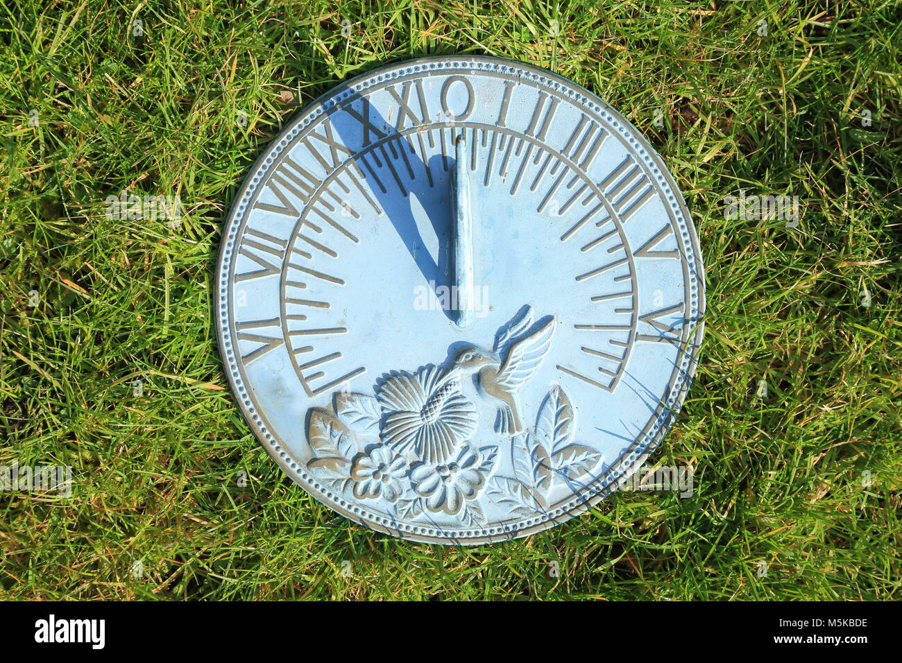 Vintage horizontal sundial with shadow on the grass Stock Photo - Alamy
