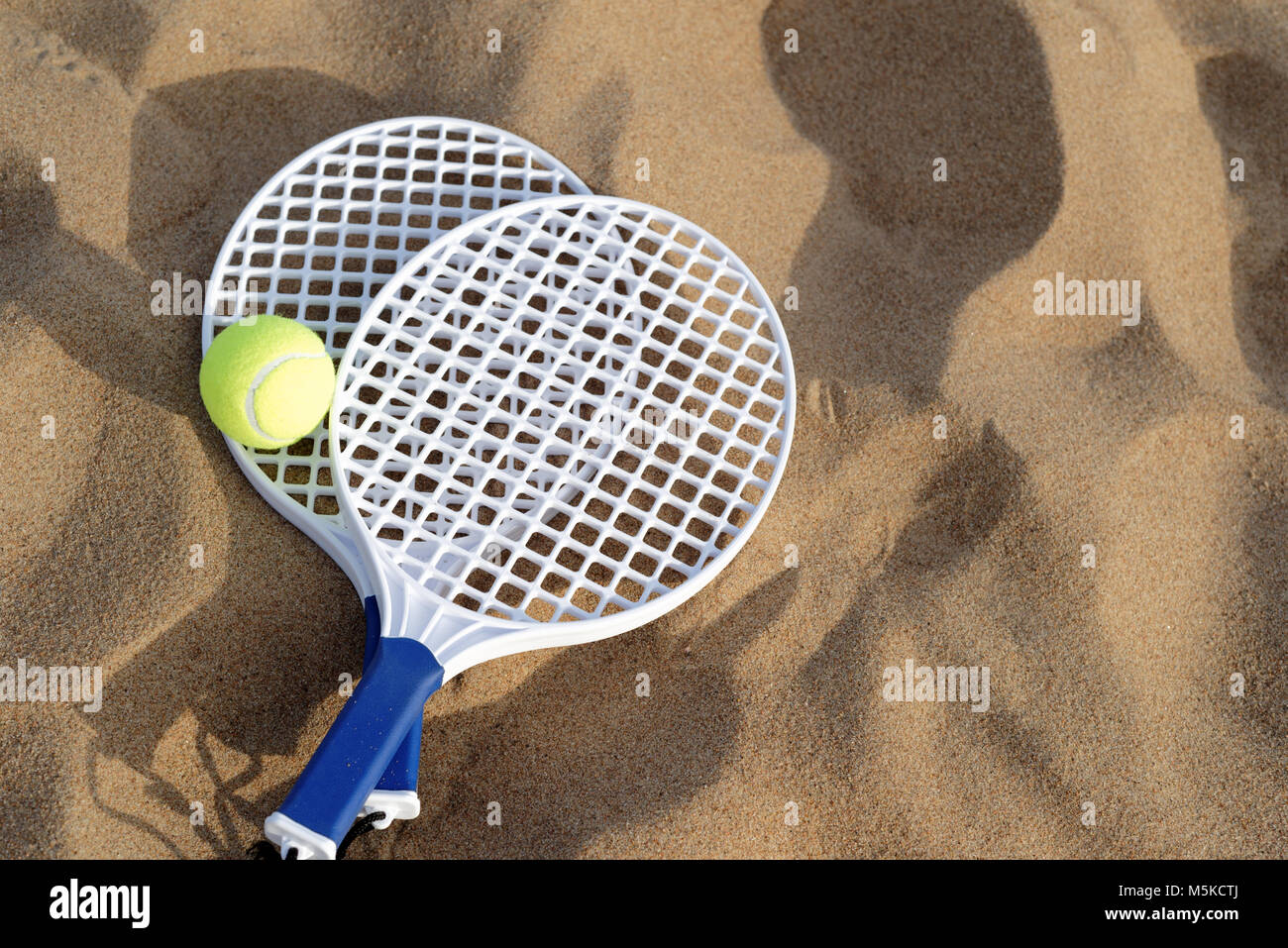 Beach tennis rackets and ball on sand Stock Photo - Alamy