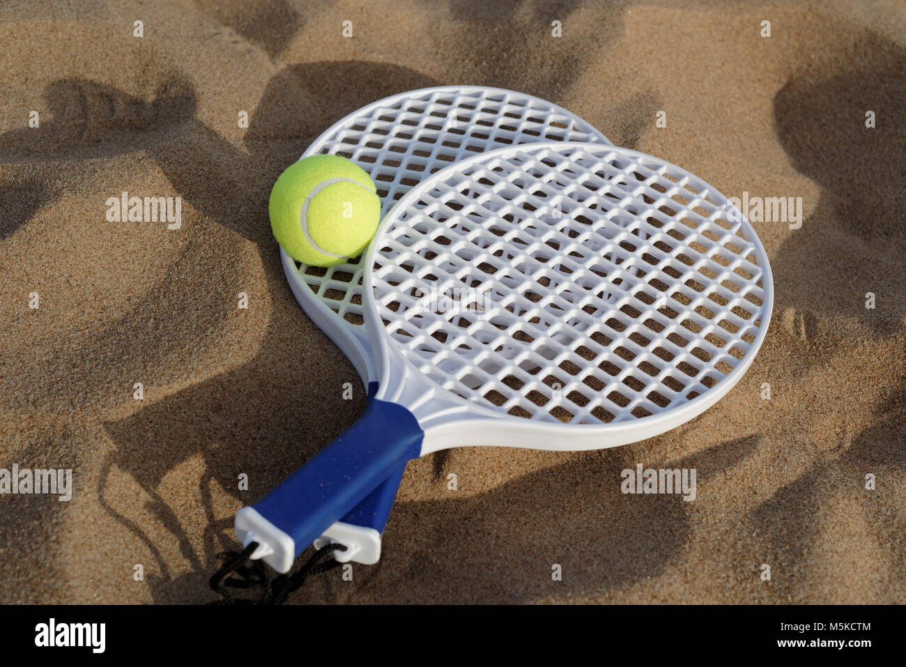 Beach tennis rackets and ball on sand Stock Photo - Alamy