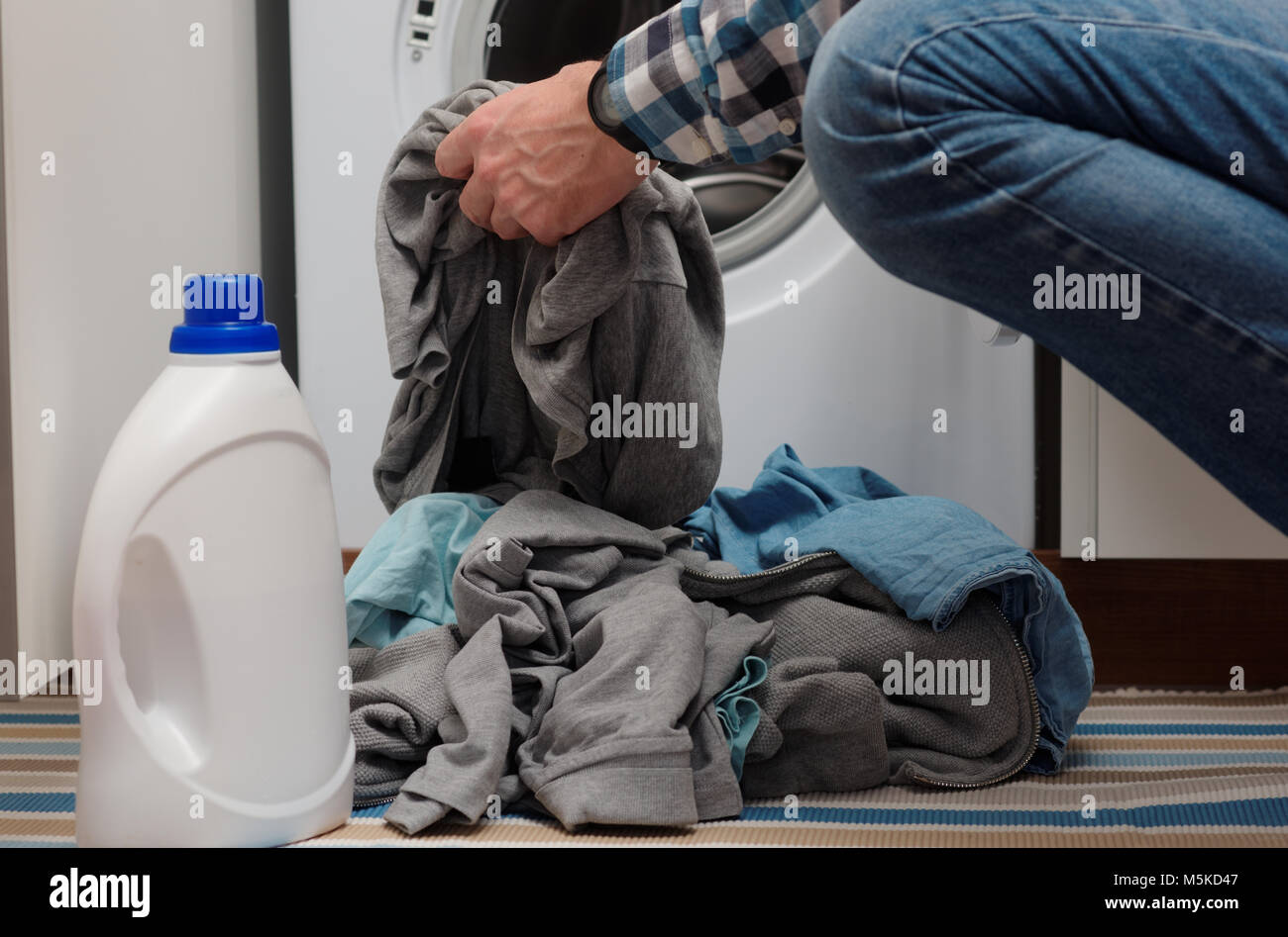 Man putting dirty clothes into opened washing machine Stock Photo - Alamy