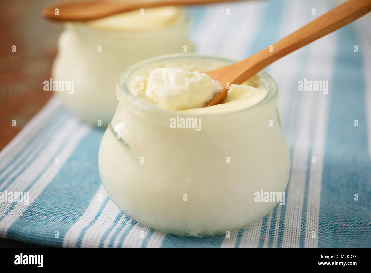 Yogurt in a jars on a rustic table Stock Photo - Alamy