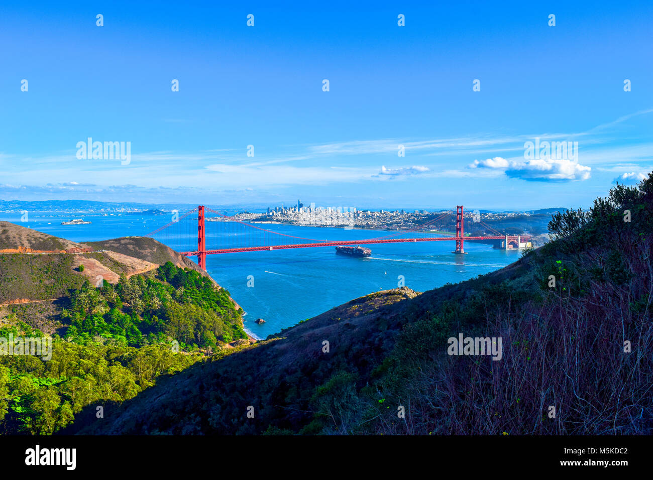 Container ship passes Golden Gate Bridge, view from the hills, San ...