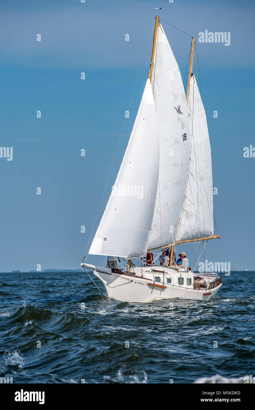 A traditional skipjack boat cuts through the choppy waters of the ...