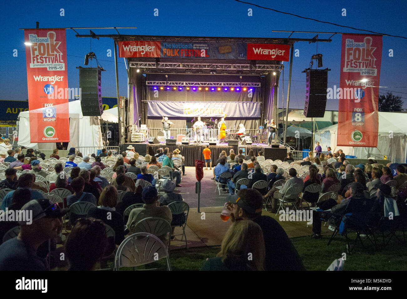 Concert goers at night sit in seats in front of stage to watch Marshall ...