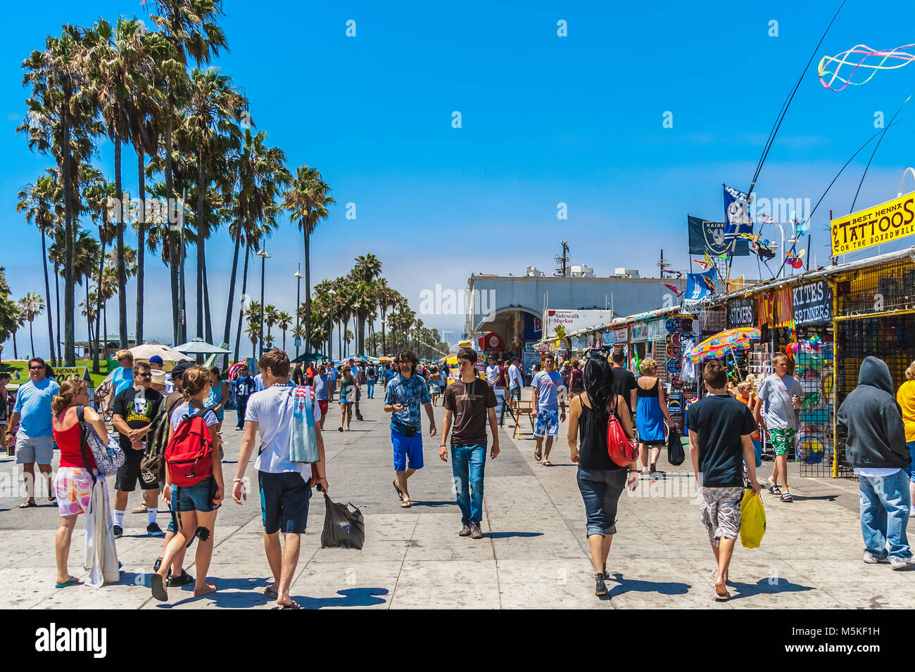 The crowded boardwalk of Venice Beach in Los Angeles during a sunny and ...