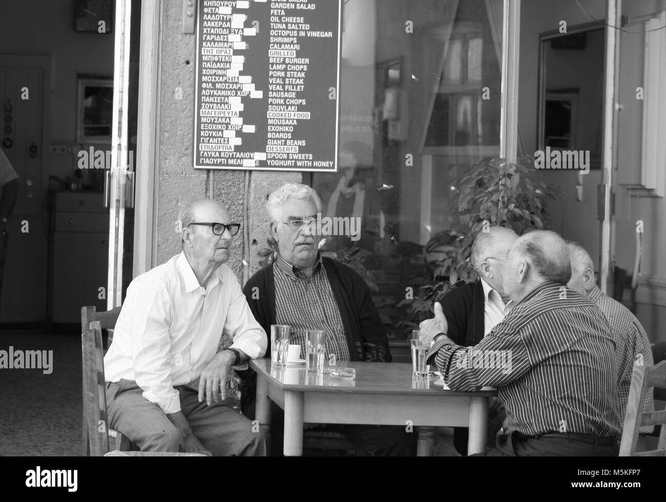 Greek men sitting at a table drinking and chatting Stock Photo - Alamy