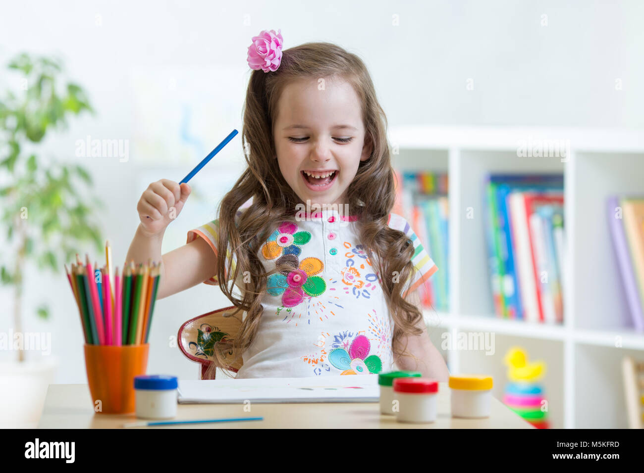 Smiling kid drawing with color pencils in day care center Stock Photo ...
