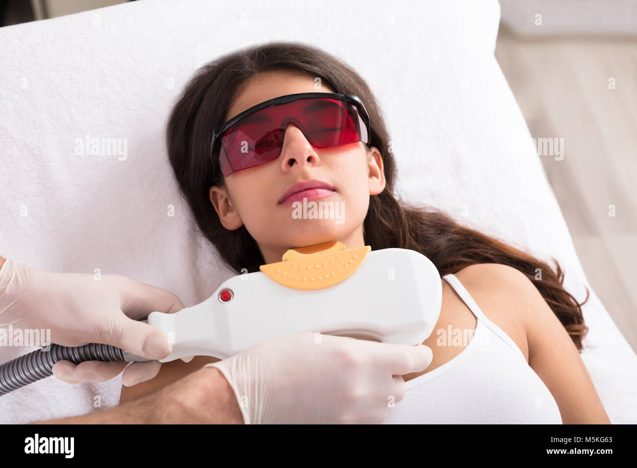 Young Woman Receiving Laser Epilation Treatment On Cheek In Beauty Spa ...