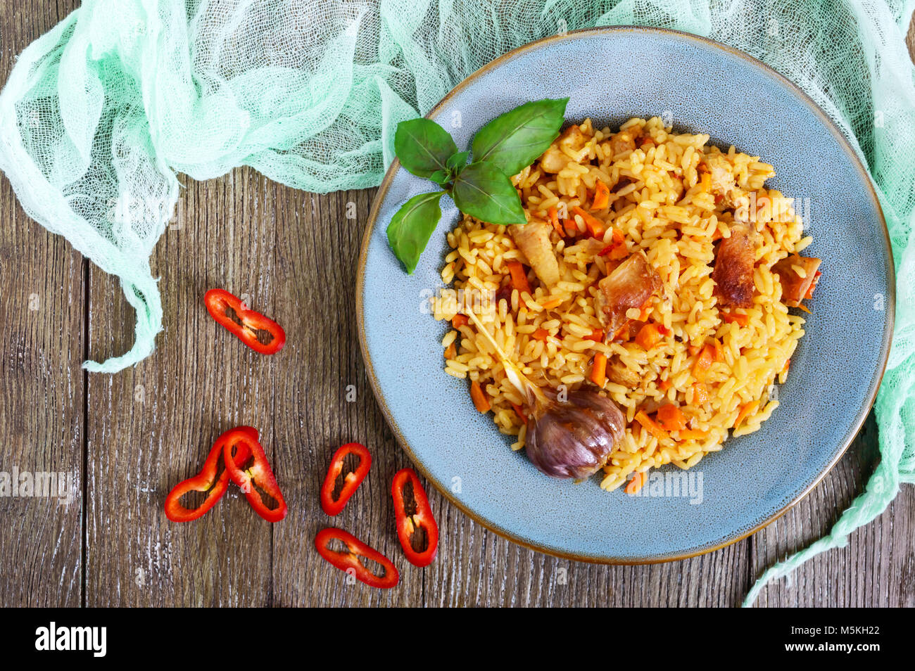 Pilaf with vegetables and dietary meat on a wooden background ...
