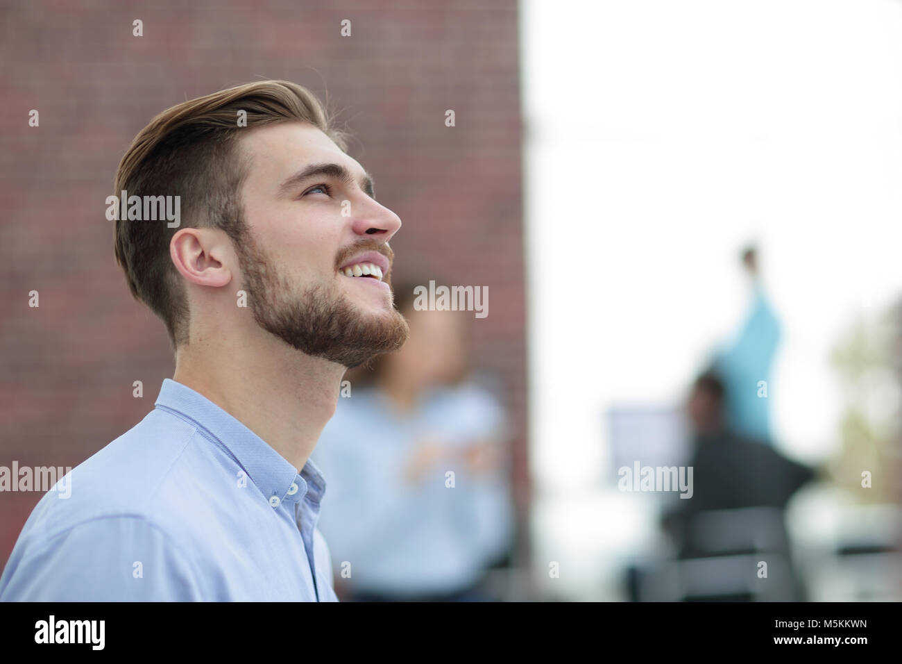 Smiling businessman in profile on office background Stock Photo - Alamy