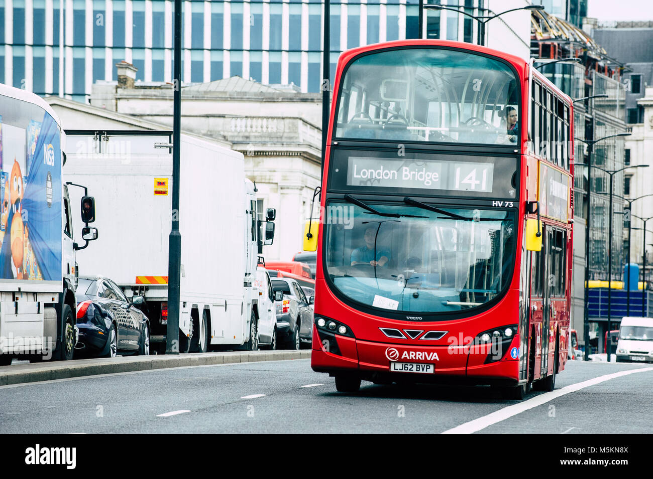 A Red London Bus travelling across London Bridge Stock Photo - Alamy