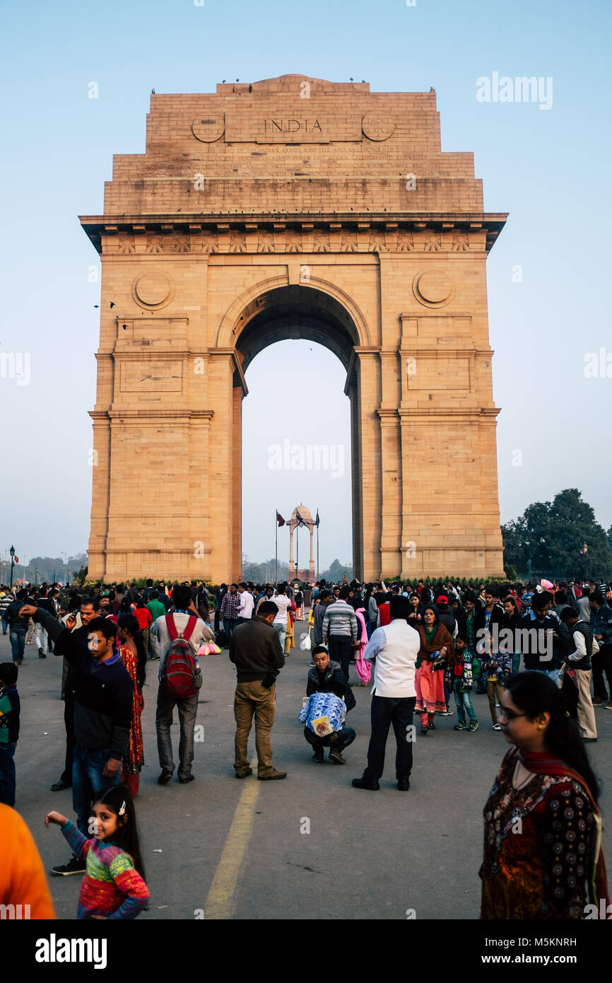 The India Gate in Delhi, India is seen at sunset amongst a busy ...