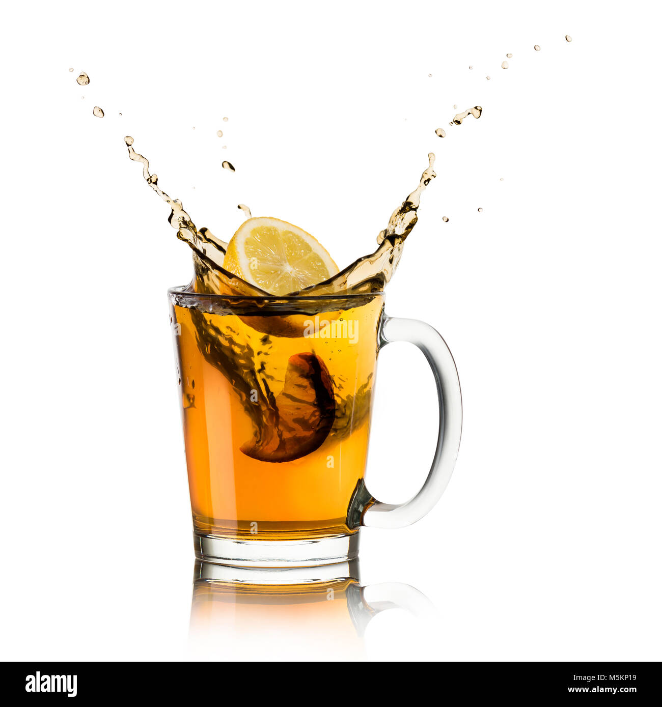 glass cup of tea with lemon slices falling and splashing, on white ...