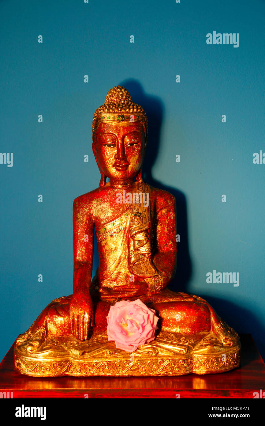Statue of a red golden buddha Stock Photo - Alamy