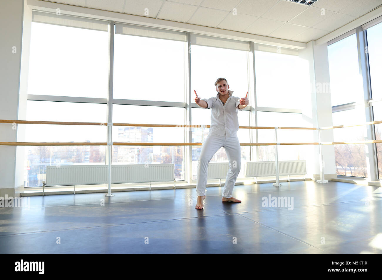 Young blonde dancer enjoys winning in white suit and makes warm Stock ...