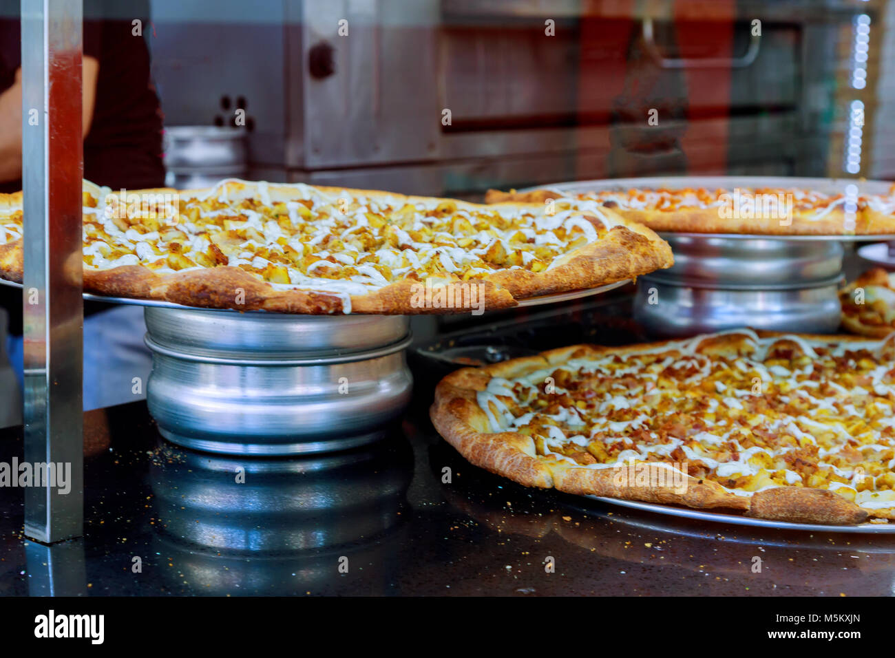 Pizza resting on a pizzeria counter the background is restaurant One ...