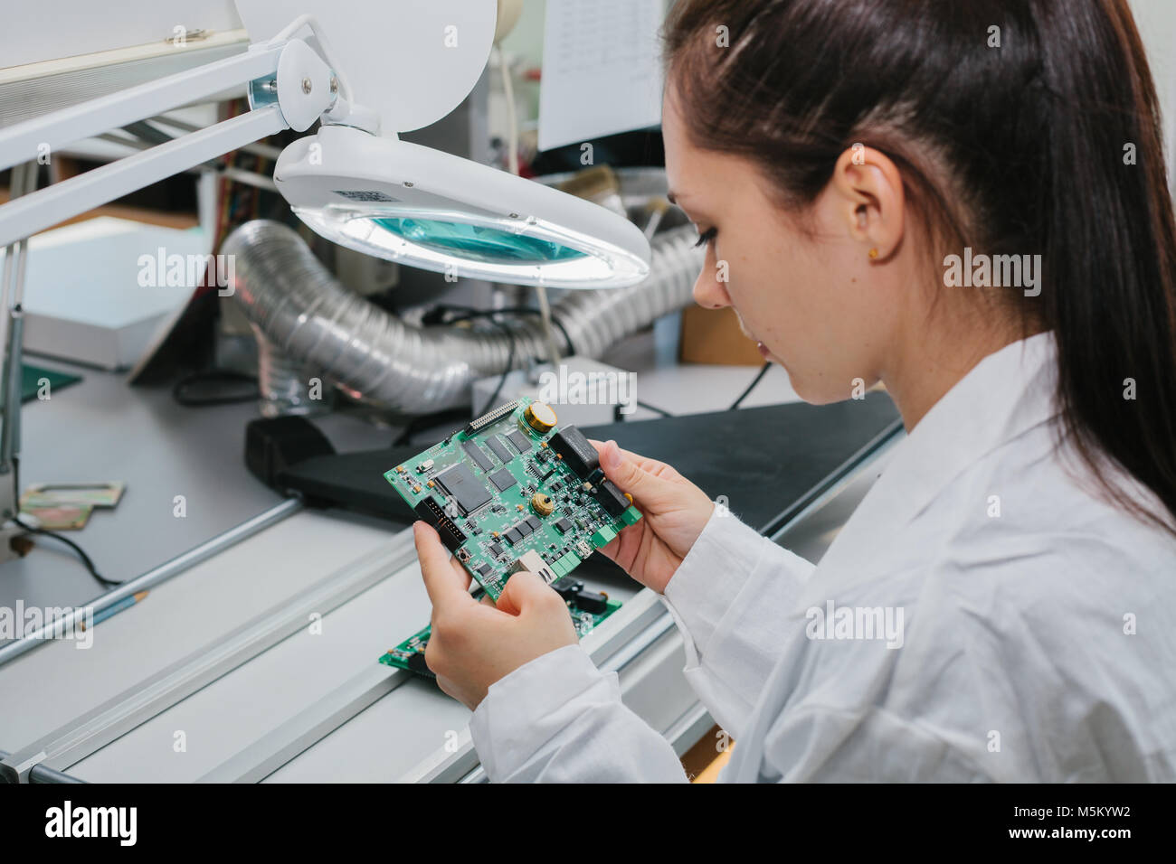Beautiful female computer expert professional technician examining ...