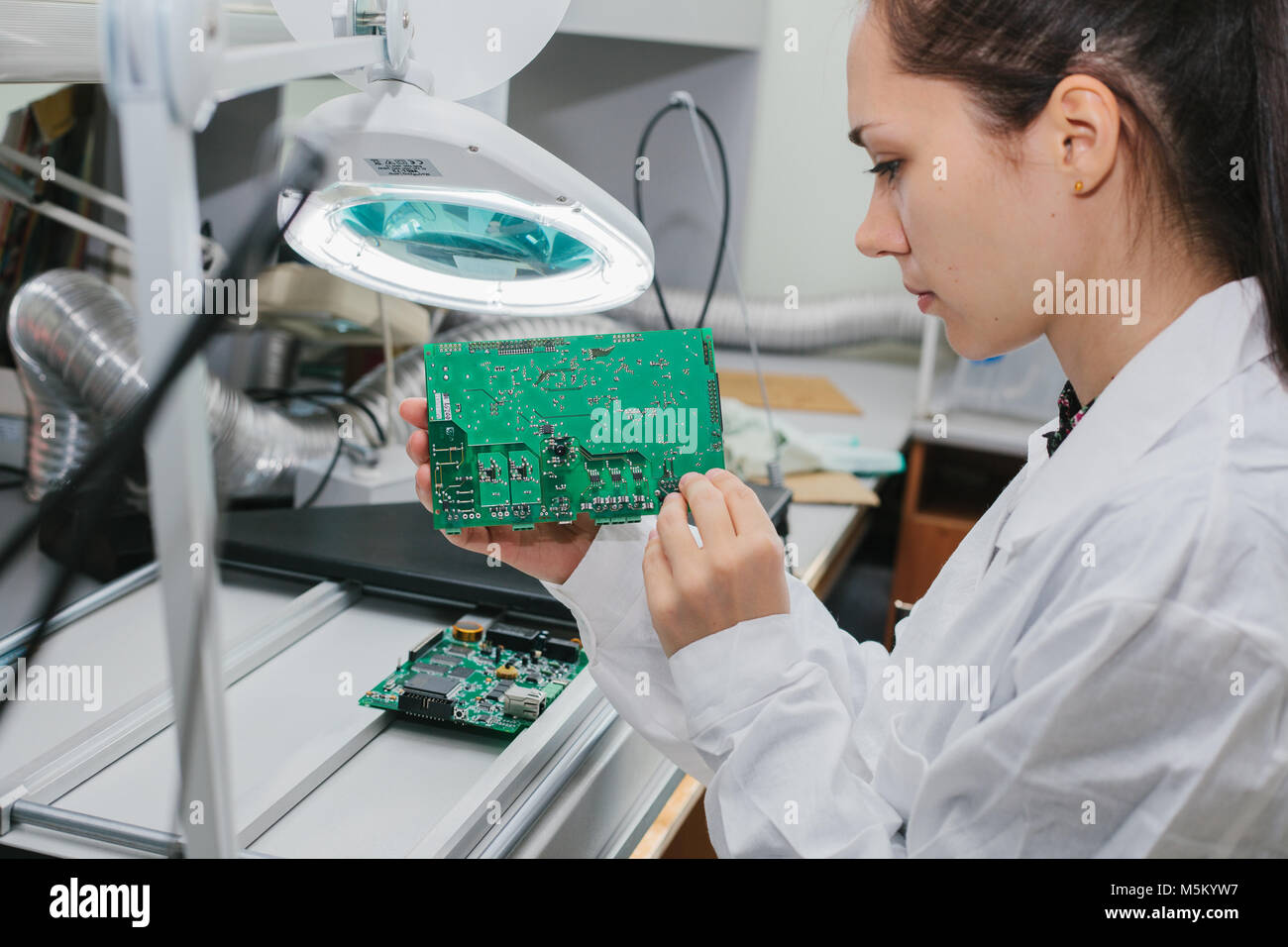Beautiful female computer expert professional technician examining ...