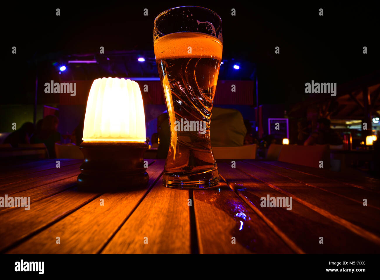 Glass of beer on the table at the restaurant during night time Stock ...