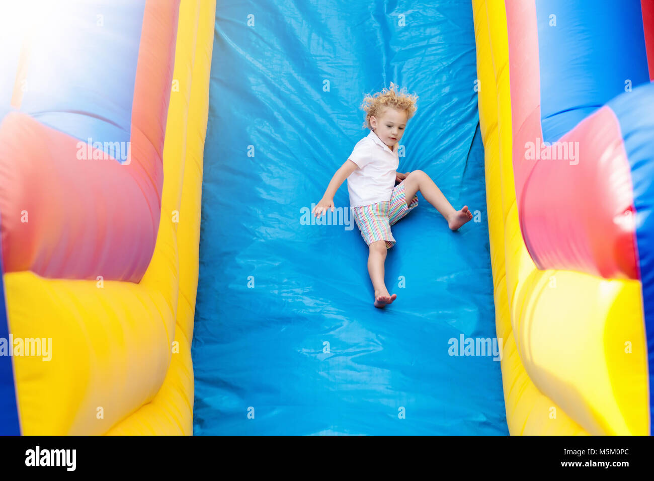 Child jumping on colorful playground trampoline. Kids jump in ...