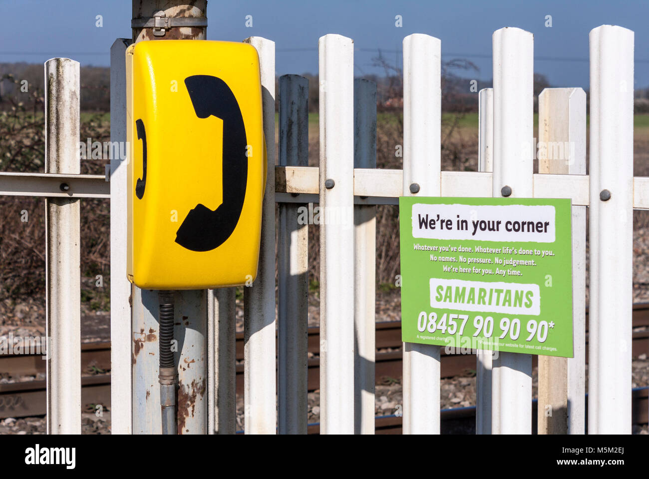Sign for the Samaritans charity next to an emergency telephone callbox ...