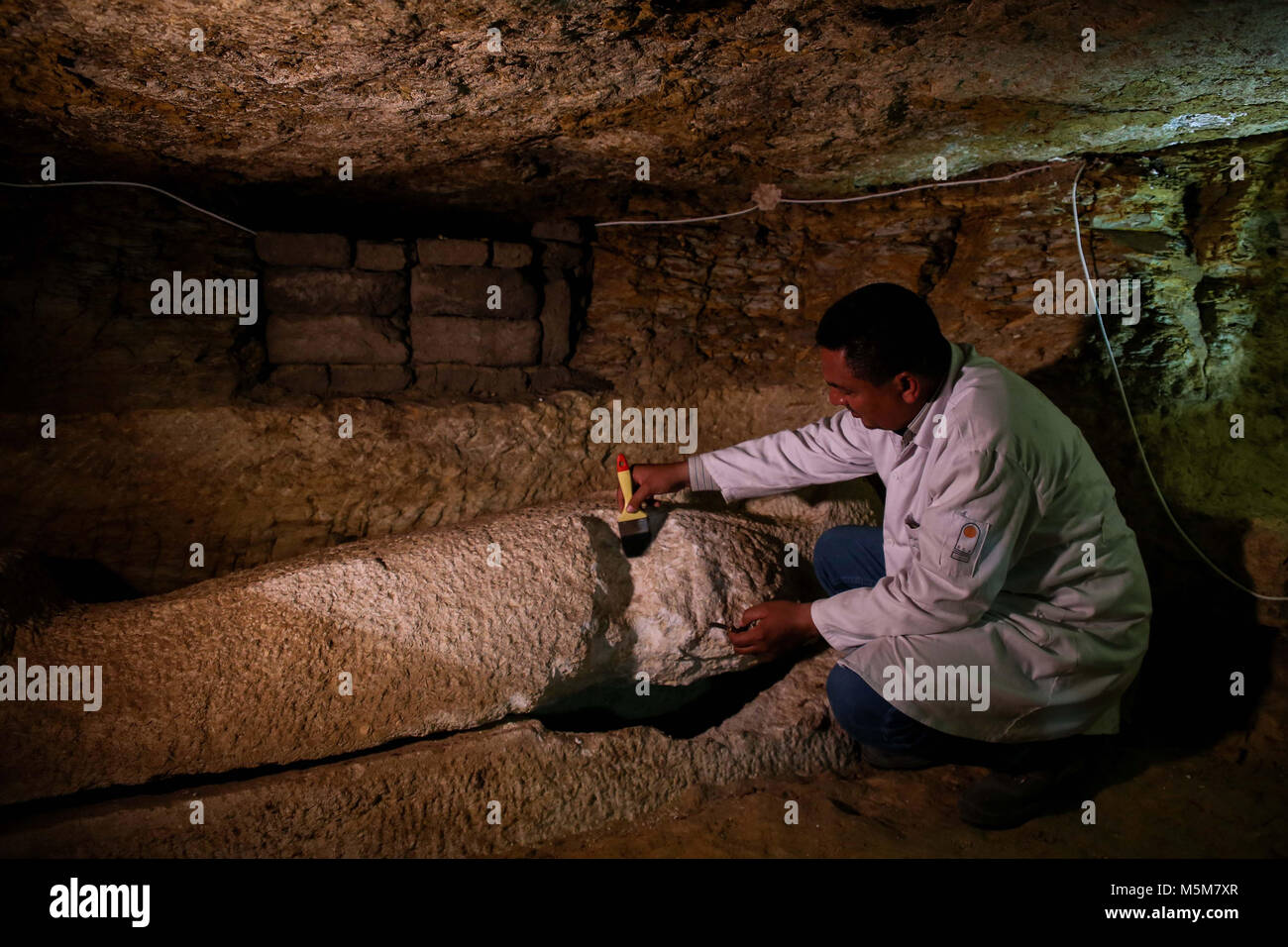 An Egyptian excavation worker works on a sarcophagus is seen in a newly ...