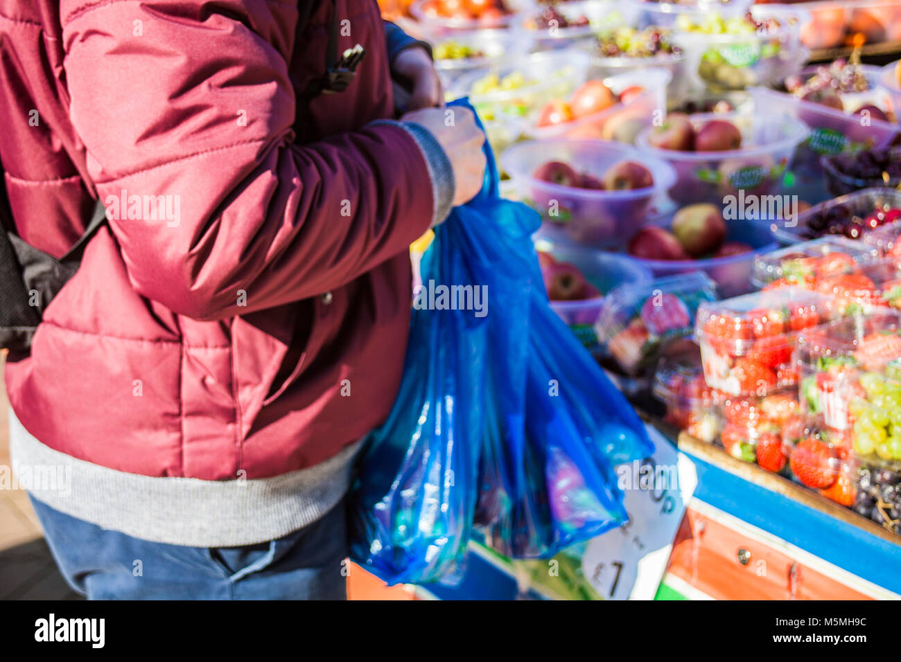 Male consumer at an open street market shopping fruit and vegetables ...