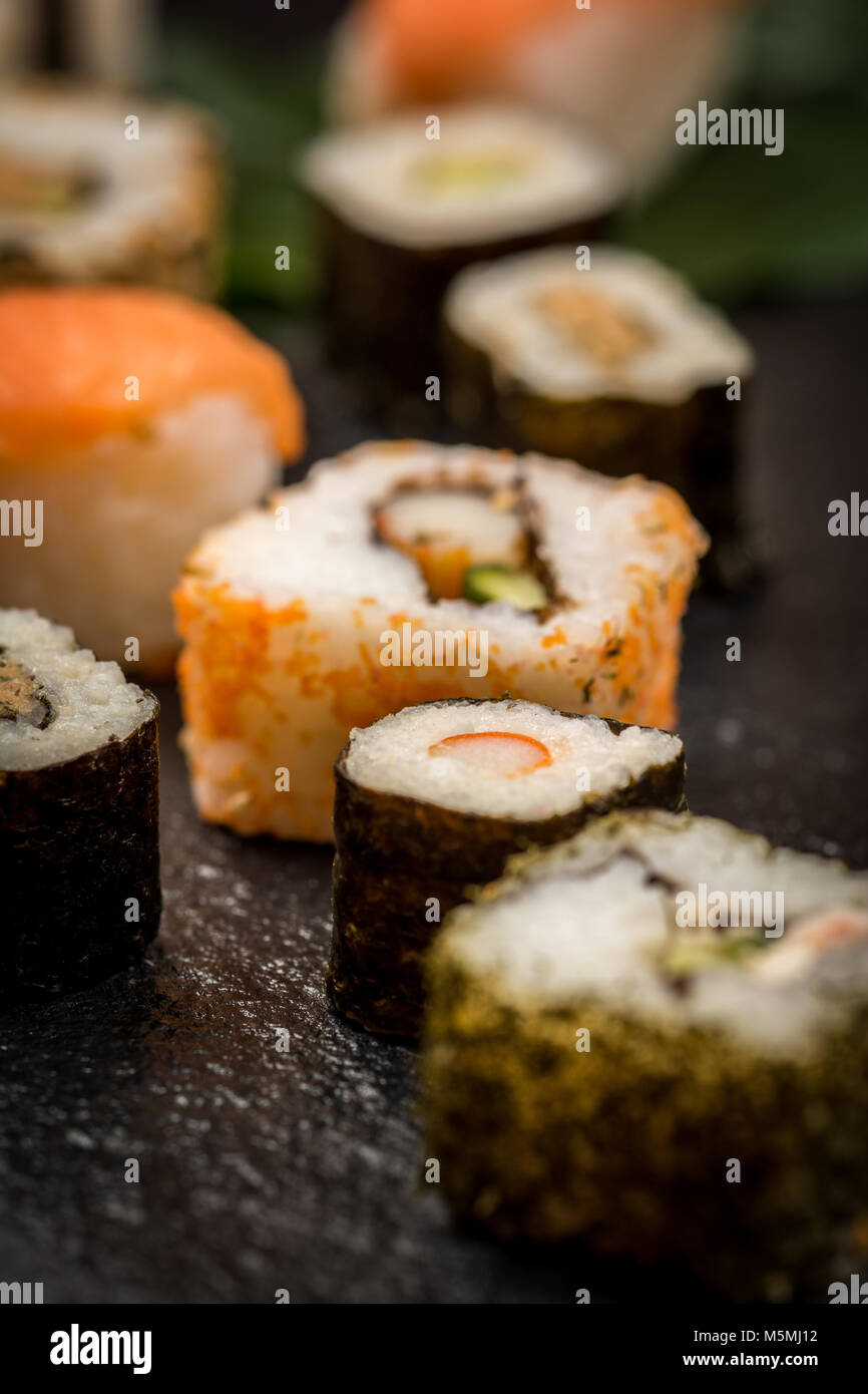 Traditional japanese sushi rolls hosomaki,uramaki on stone desk Stock ...