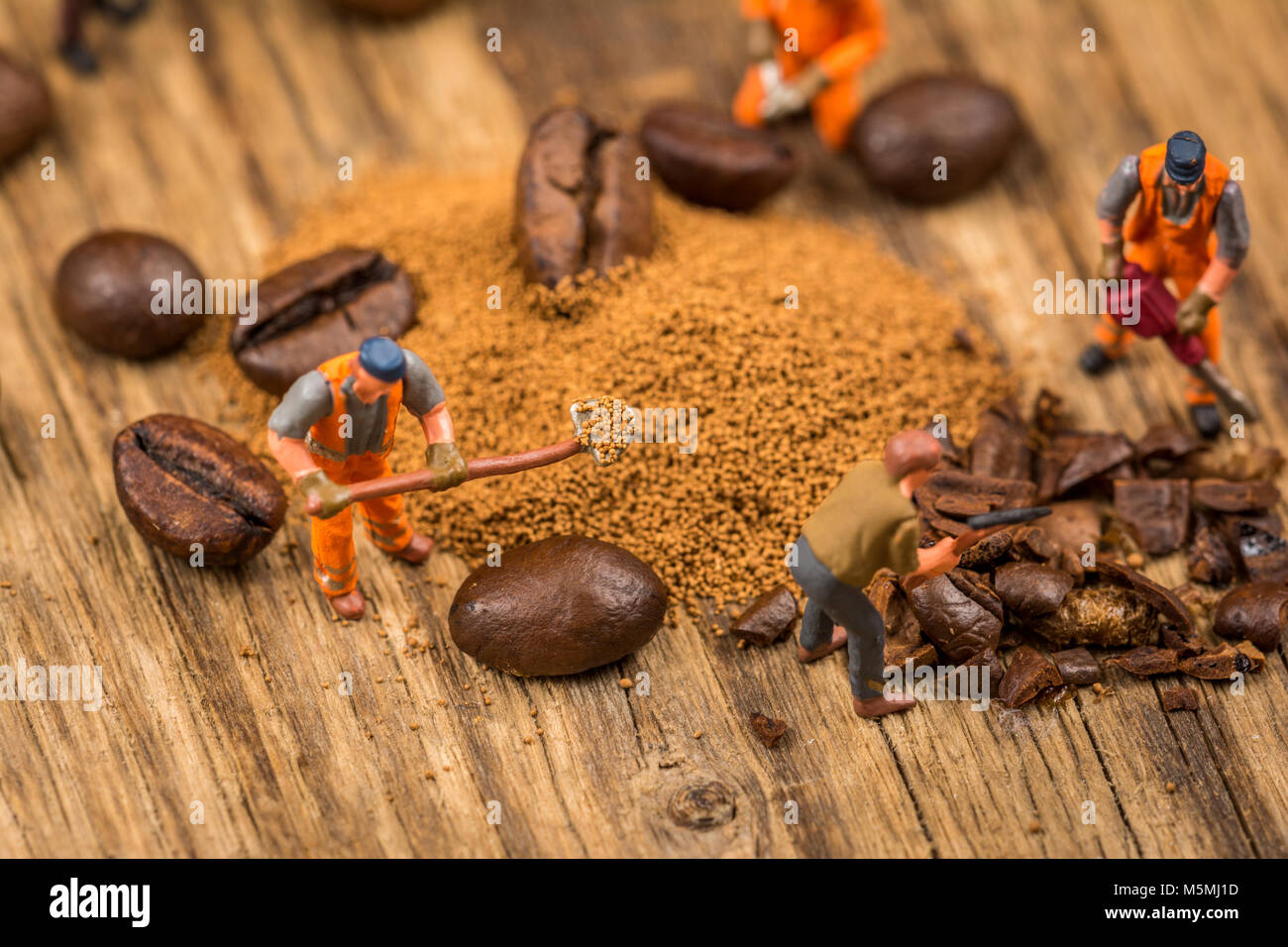 Miniature figures working on instant coffee macro photography on wood ...