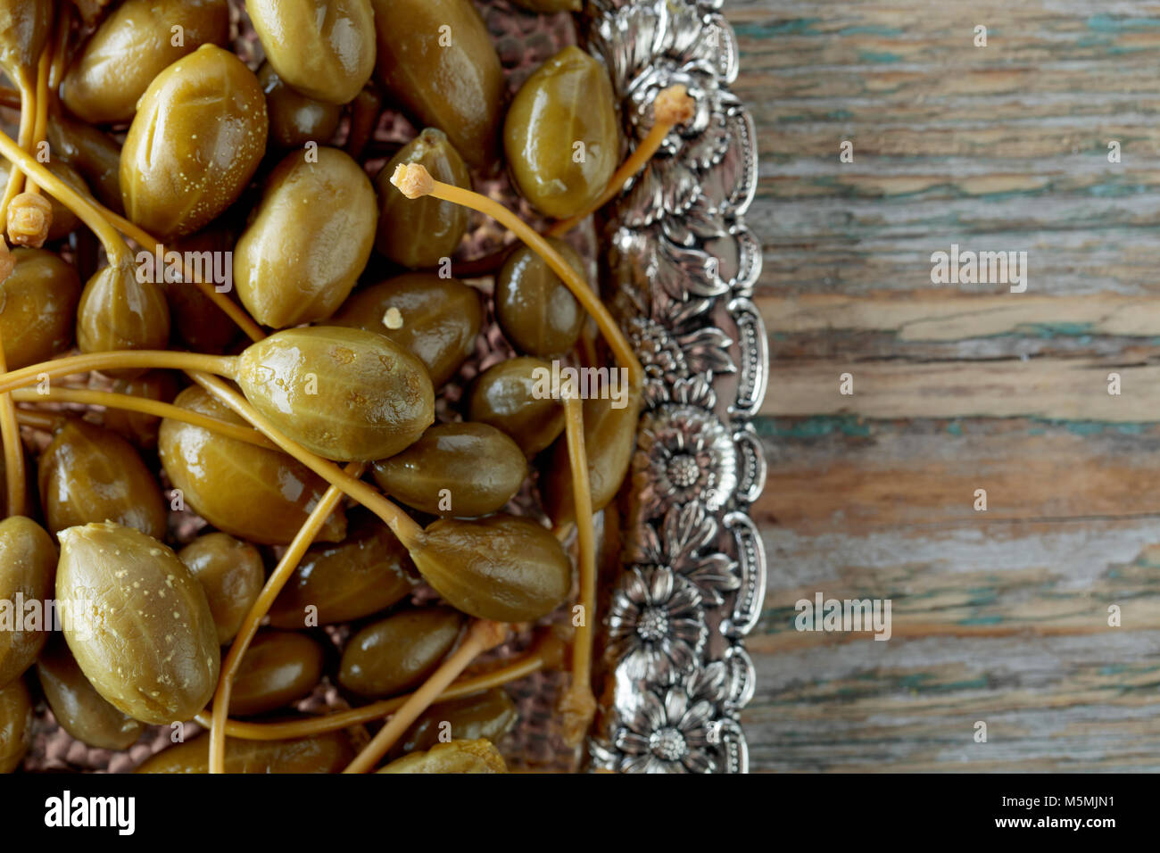 Pickled caper berries in metal dish . Edible fruits of Capparis ...