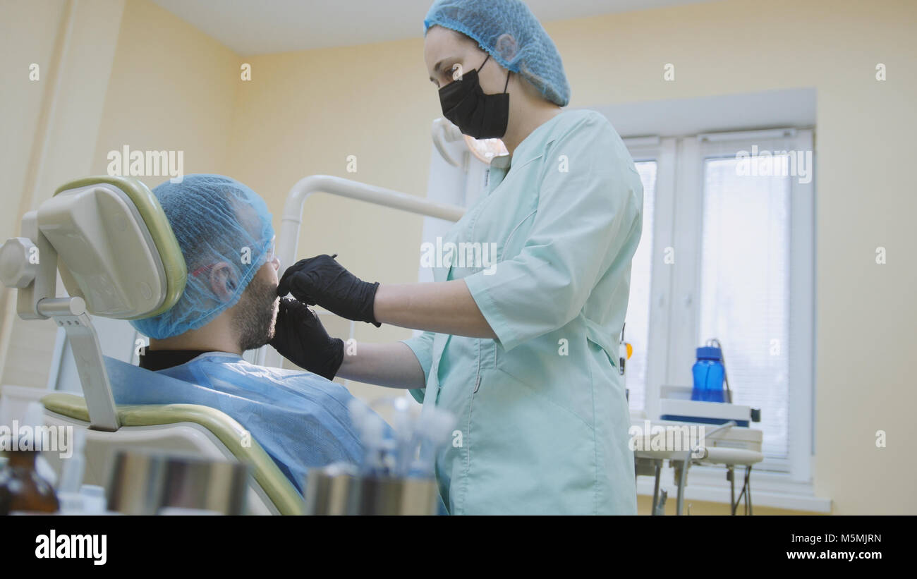 Doctor and patient in the dental office, washing the mouth Stock Photo ...