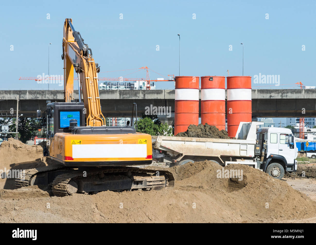 Large excavator is loading the sand and soil in to the truck for ...