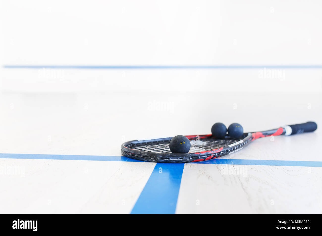 squash racket and balls on the wooden floor. Racquetball equipment on ...