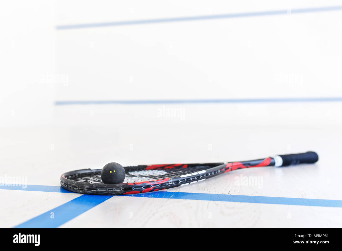 squash racket and ball on the wooden floor. Racquetball equipment on ...