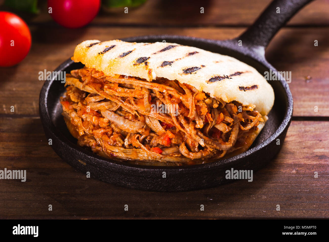 Freshly cooked Arepa with roasted meat on wood table Stock Photo - Alamy