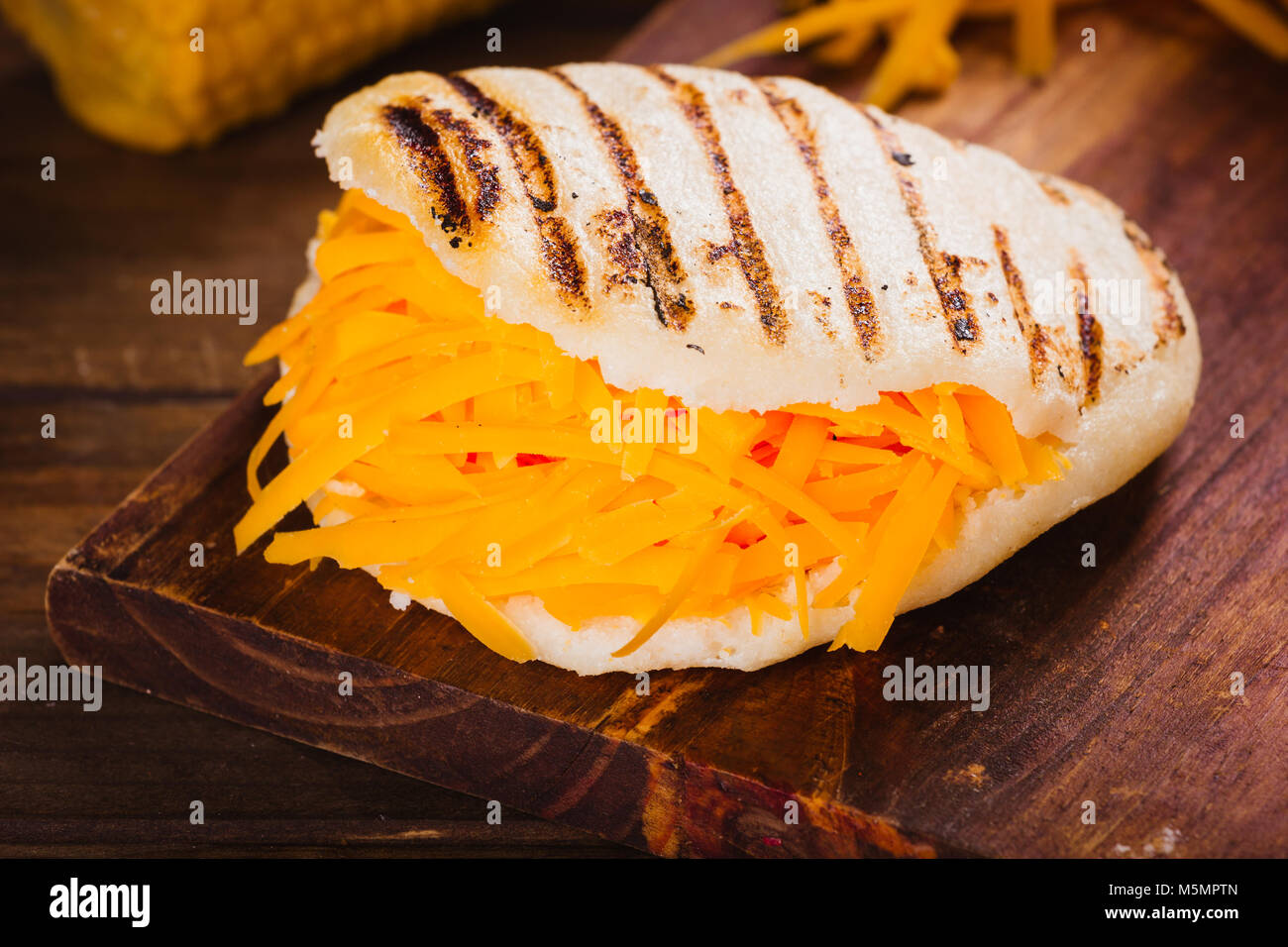 Arepa, corn bread with cheese on wood table Stock Photo - Alamy