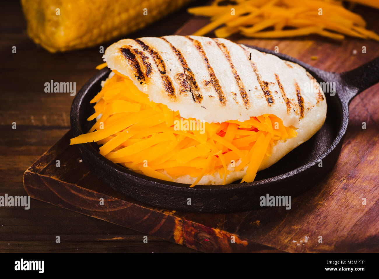 Arepa, corn bread with cheese on wood table Stock Photo - Alamy