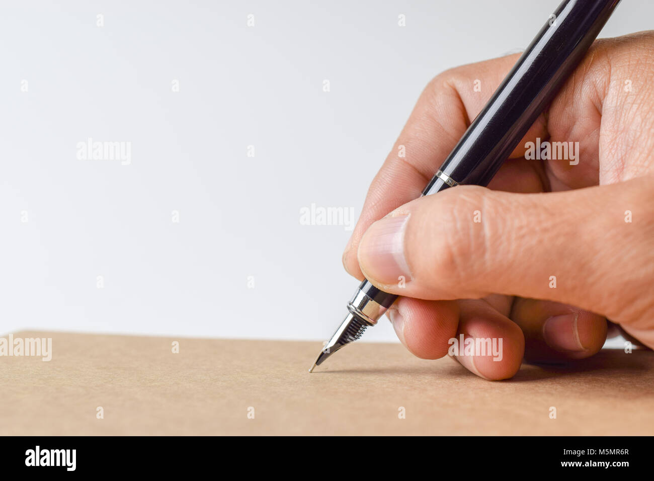 Human hand signing on formal paper at the table on white background ...
