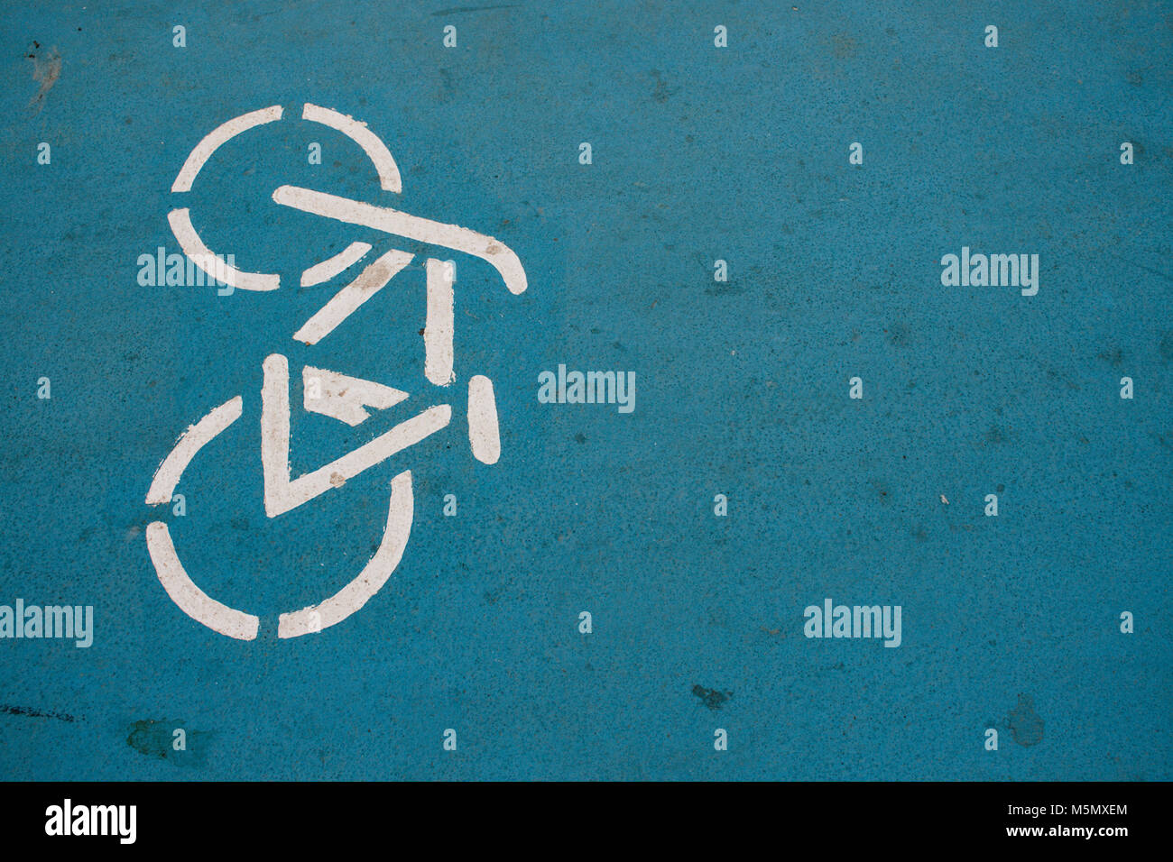 Bicycle. White bicycle sign on a blue road. Road sign Stock Photo - Alamy
