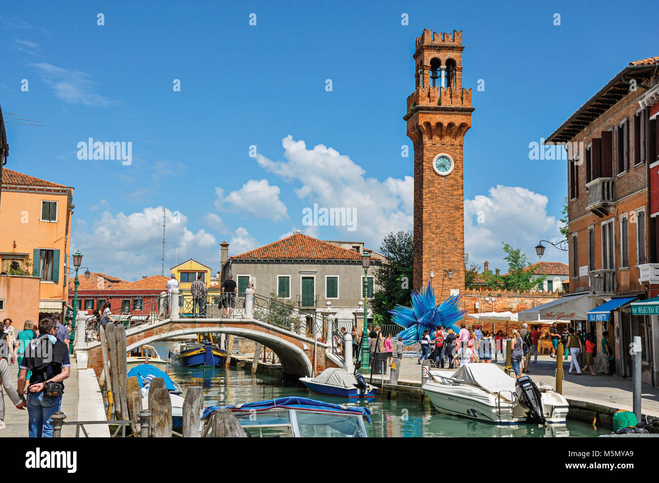 Murano, Italy. View of people, buildings and clock tower in front of ...