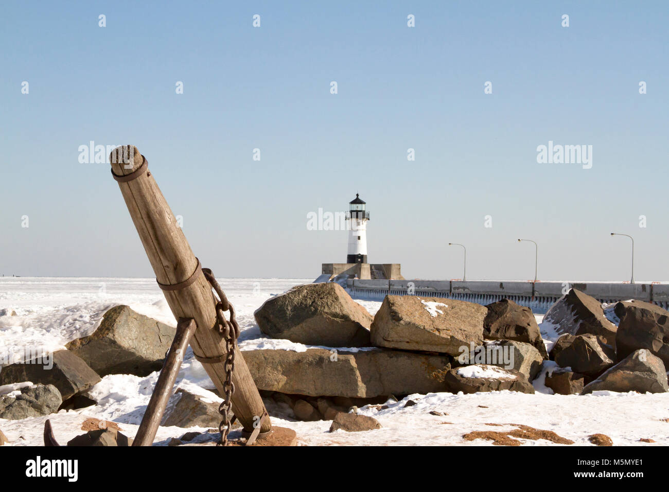 Ship anchor on shores of frozen Lake Superior next to pier along ...