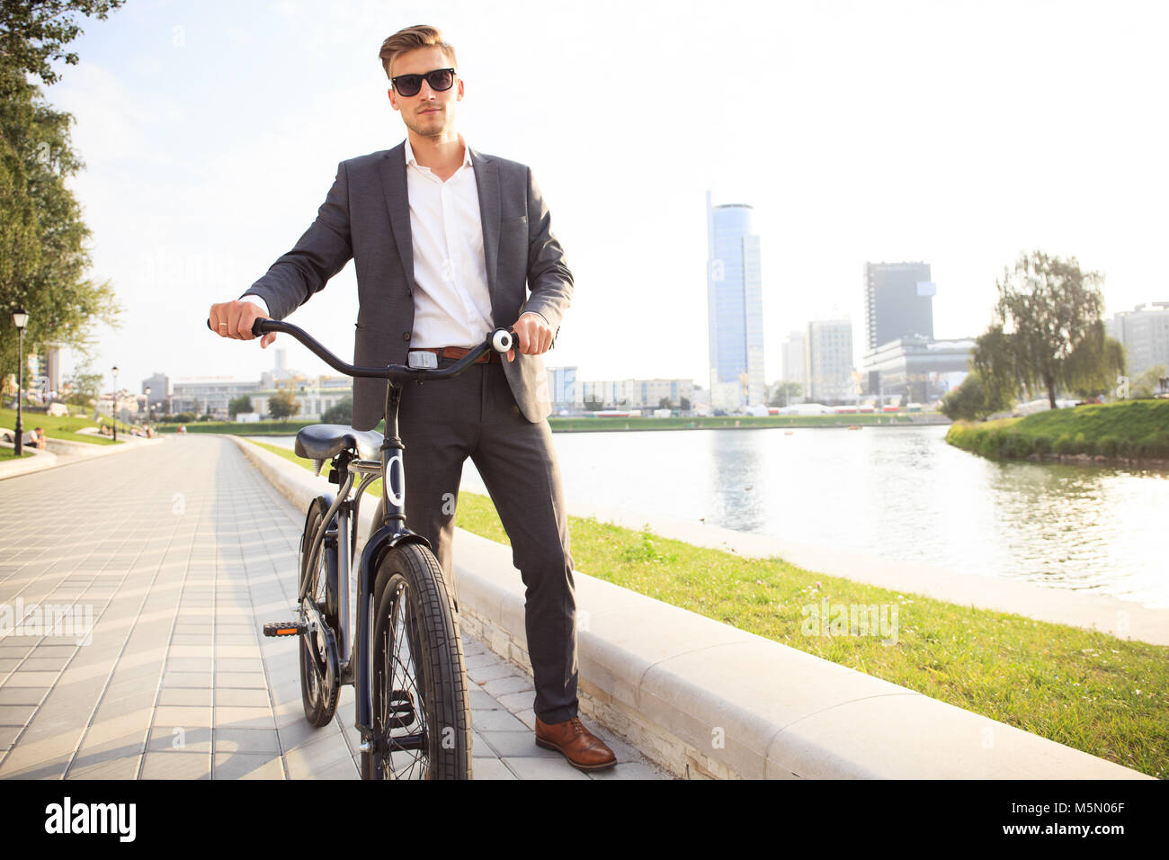 Businessman riding bicycle to work on urban street in morning Stock ...