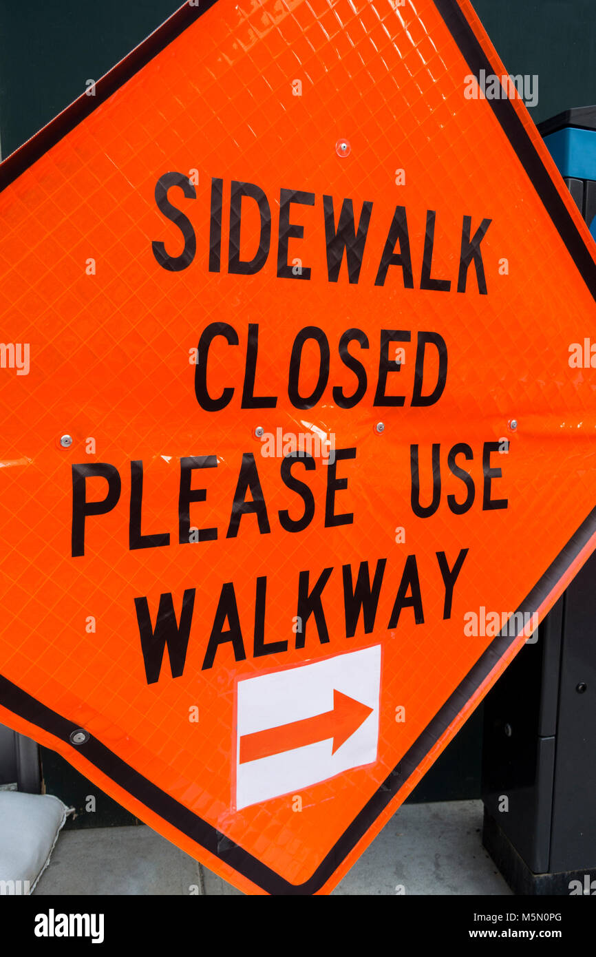 orange red sign closed side walk with arrow Stock Photo - Alamy