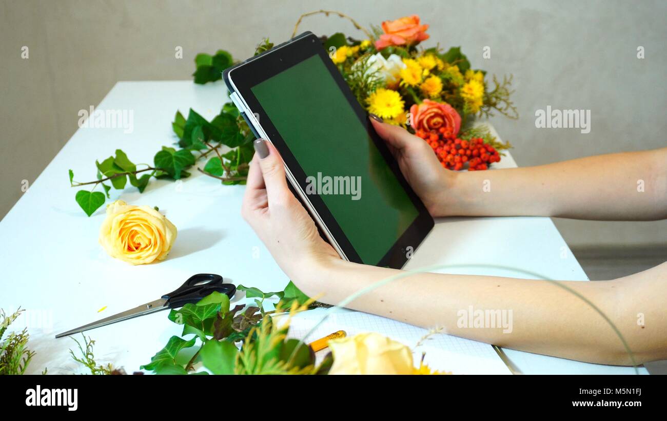 Shooting close-up of tablet and hands of female flower designer Stock ...